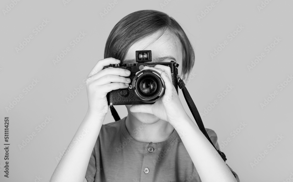 Little boy on a taking a photo using a vintage camera. Child in studio ...