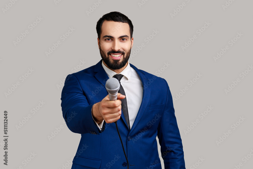 Portrait of smiling positive bearded man standing and offering ...