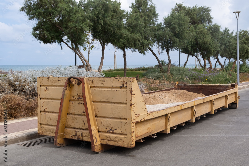 Dumpster Waste metal tank container filled with ground, rubble near a ...