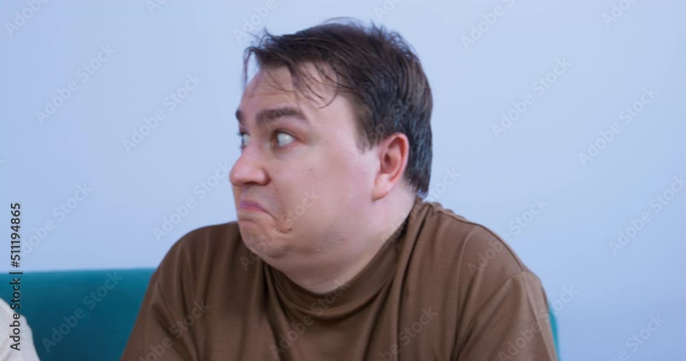 Vidéo Stock Camera shows frowning man who looks questioningly at ...