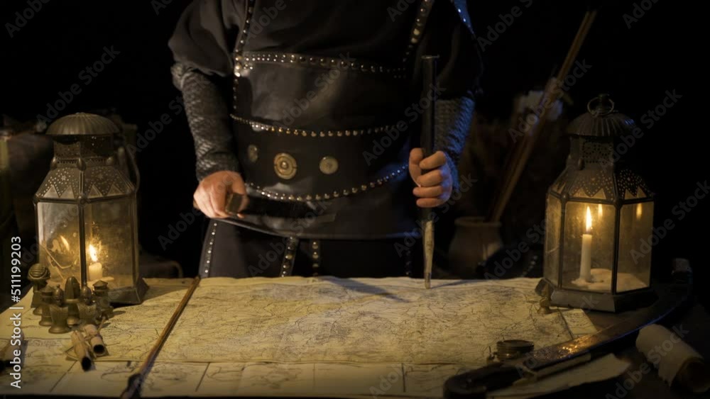 Commander working on map with sword in hand. The commander takes his ...