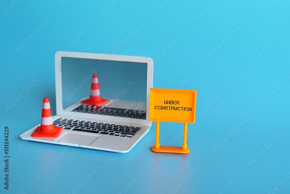 Website under construction concept. Laptop, safety cone and signboard ...