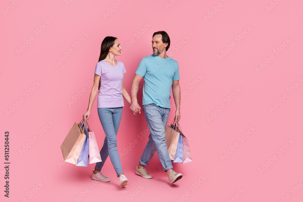 Full length portrait of lovely people hold arms walking hold packages ...