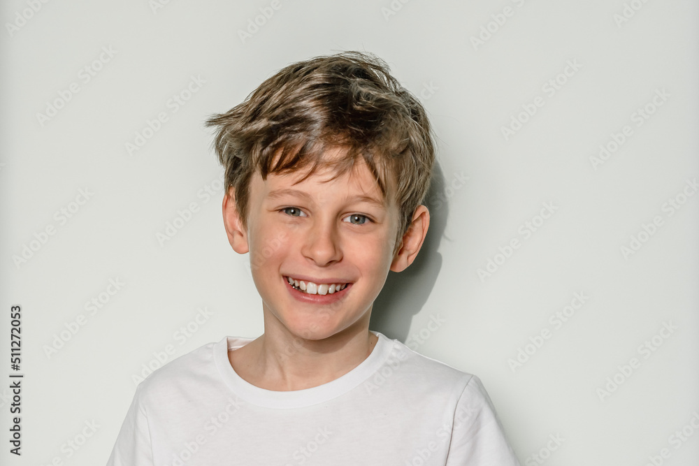 Laughing boy. Portrait of a white caucasian 9 year old boy in a white t ...