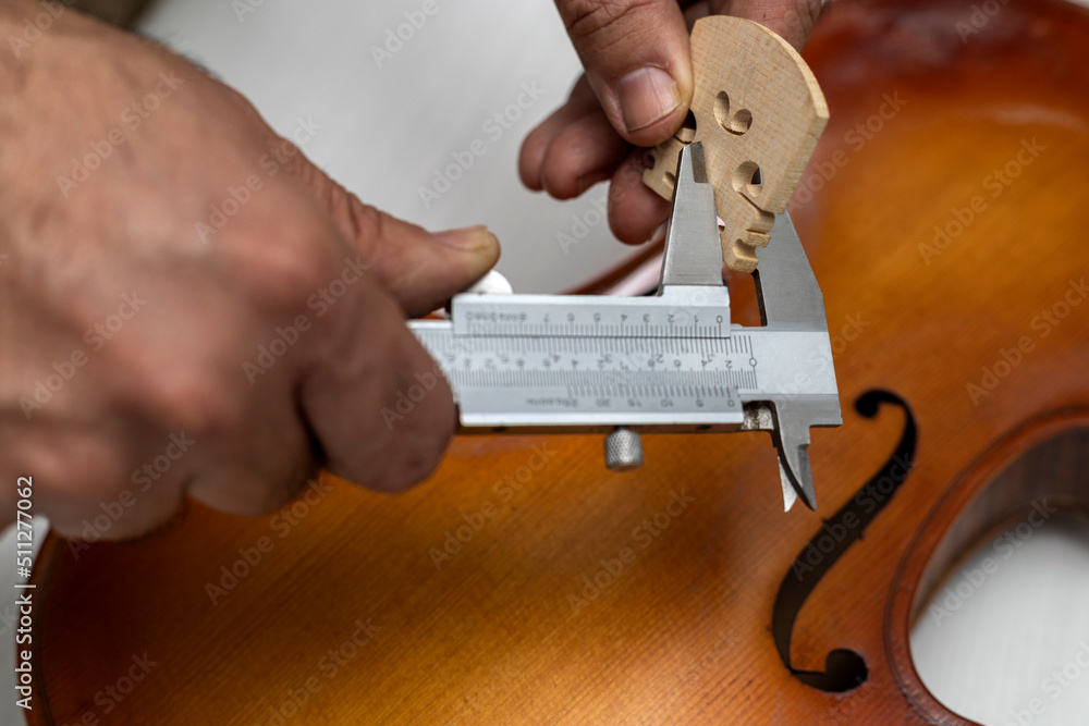 Hands of an unrecognizable Latin American luthier taking precise ...