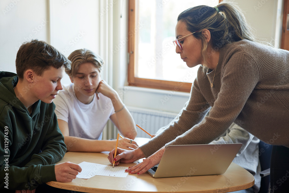 Teacher helping students in class Stock Photo | Adobe Stock
