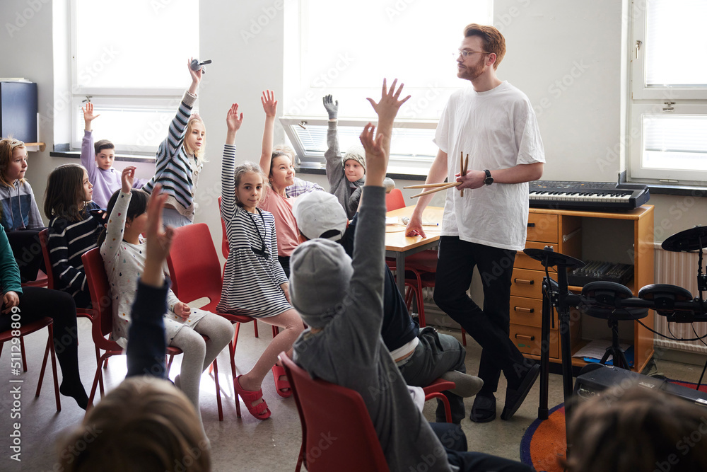 Children raising hands in class Stock Photo | Adobe Stock