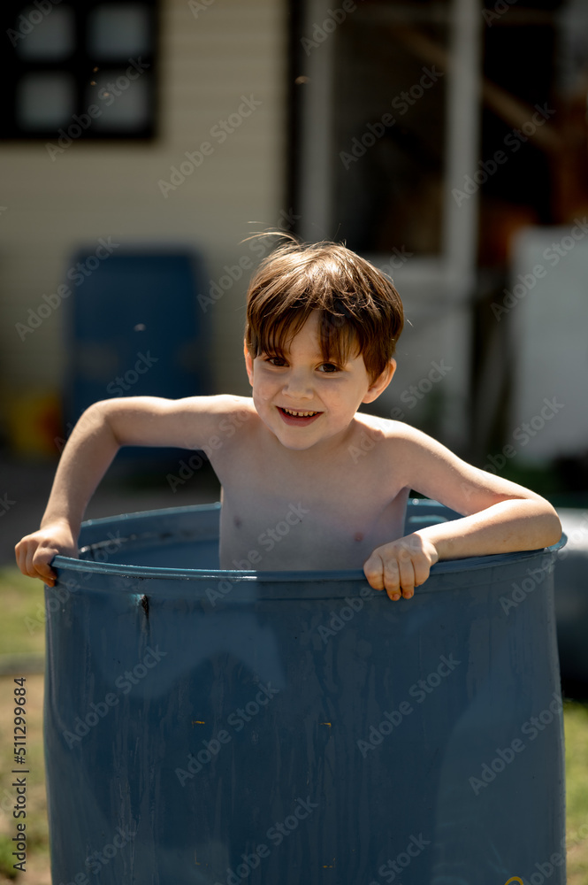 the boys are bathing in a barrel. Children have fun spending the summer ...