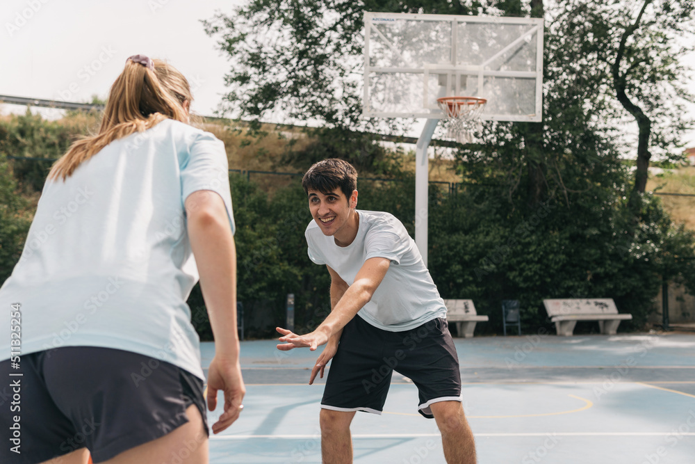 Sportswoman trying to dribble her partner on the basketball court ...