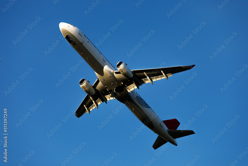 A large modern plane flies in the sky, a view from below from the ...