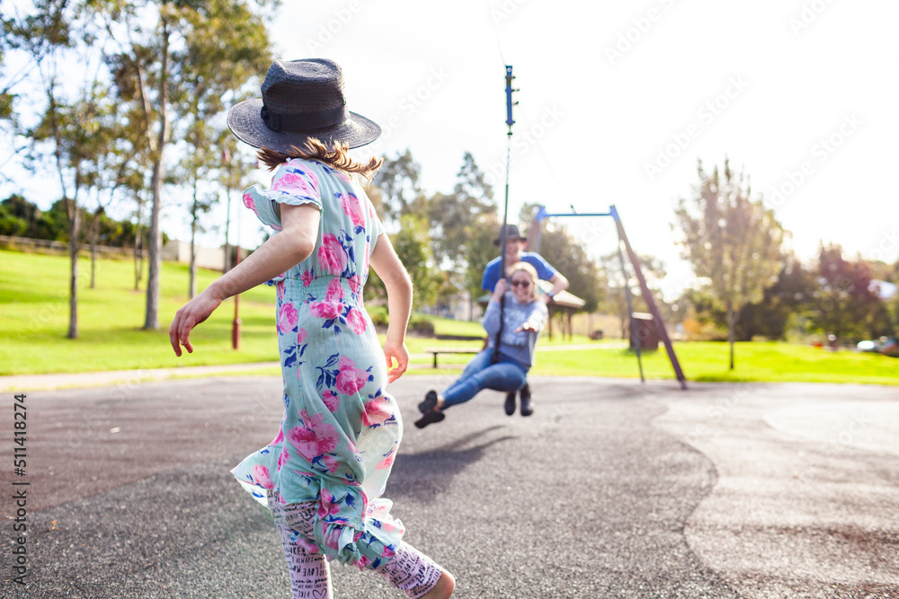 Child, teen and young adult siblings playing together on flying fox ...