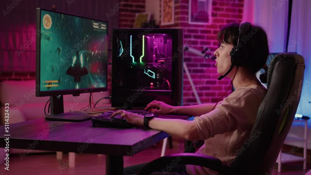 Woman relaxing and streaming on internet fast paced space shooter ...