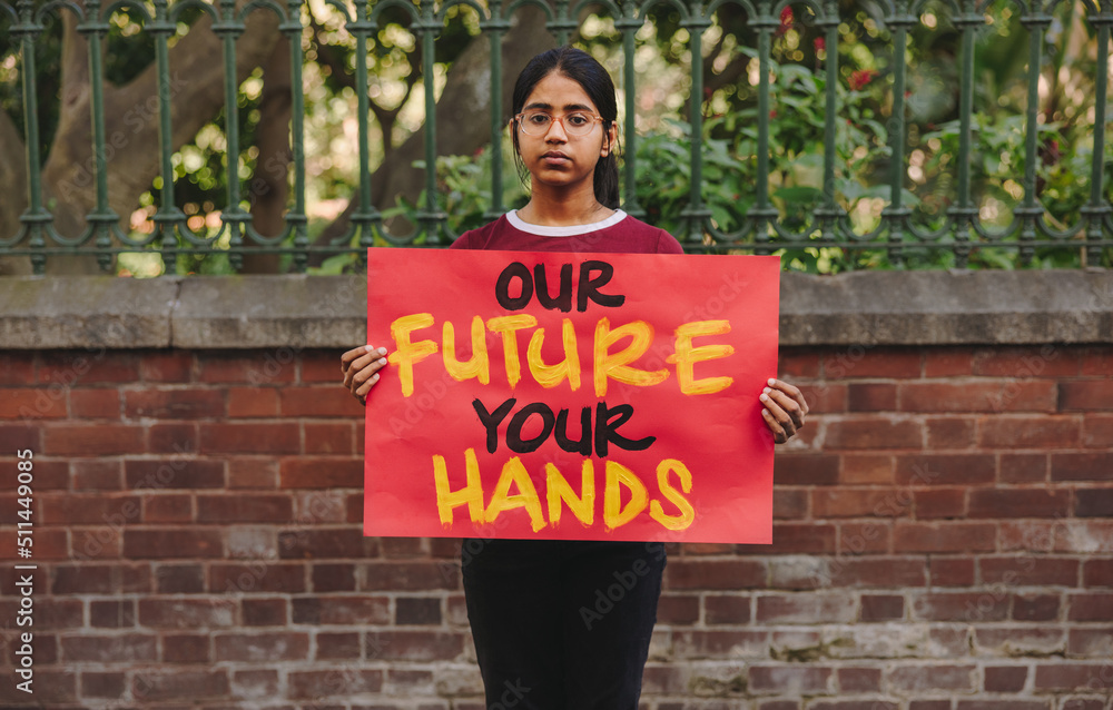 Young girl holding a climate change poster outdoors Stock Photo | Adobe ...