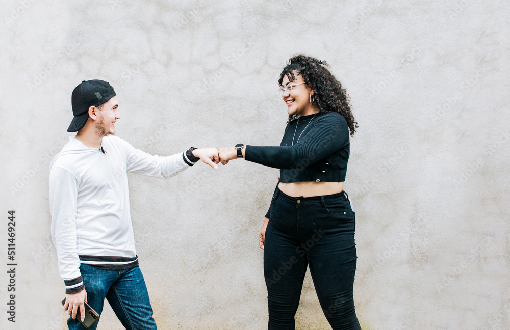 Two teenage friends bumping their fists. A guy and teenage girl shaking ... Two teenage friends bumping their fists. A guy and teenage girl shaking ...