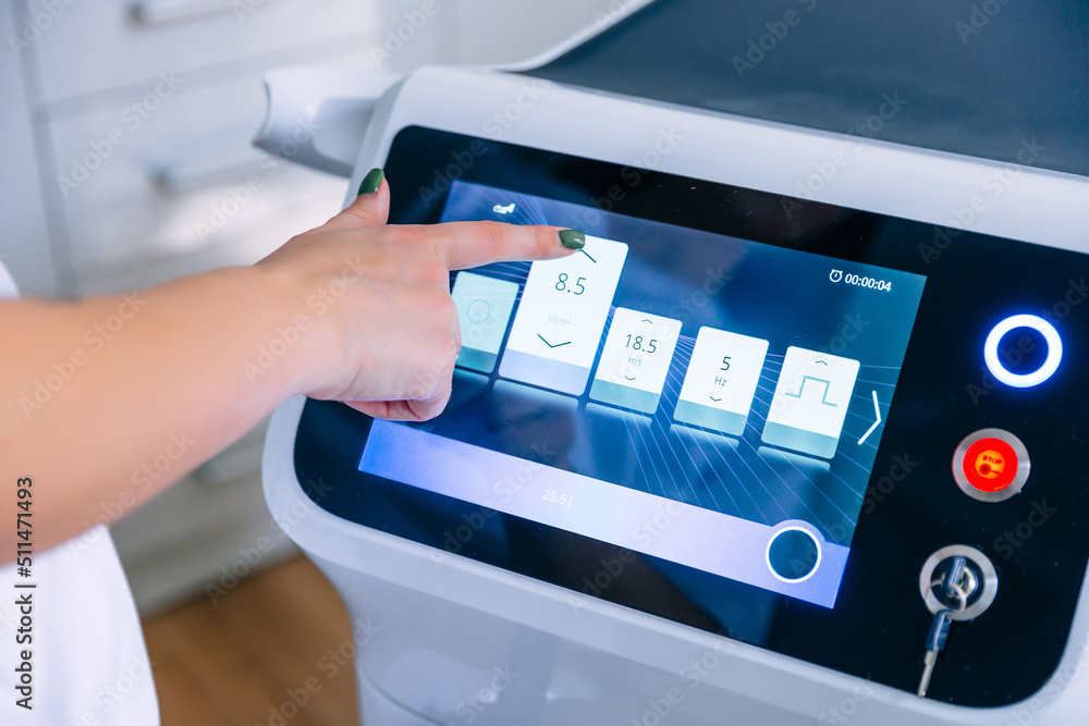 female hand adjusts the device on the touch screen before the procedure ...
