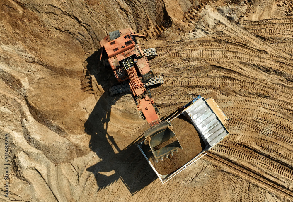 Excavator load sand into mining truck in opencast. Mining excavator in ...