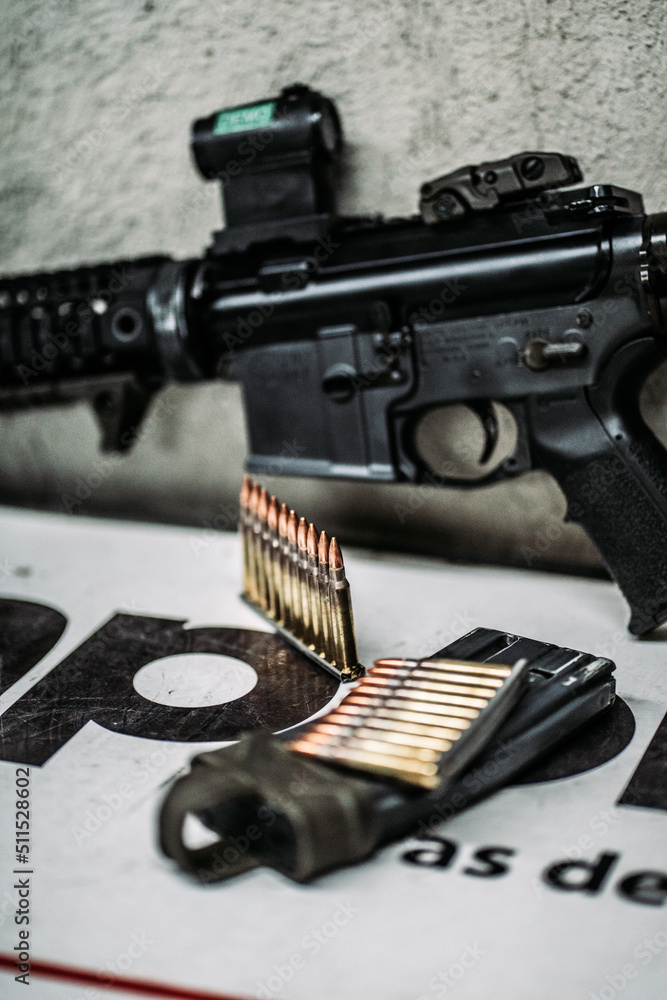 Assault rifle with red dot sight next to a box with ammunition Stock ...