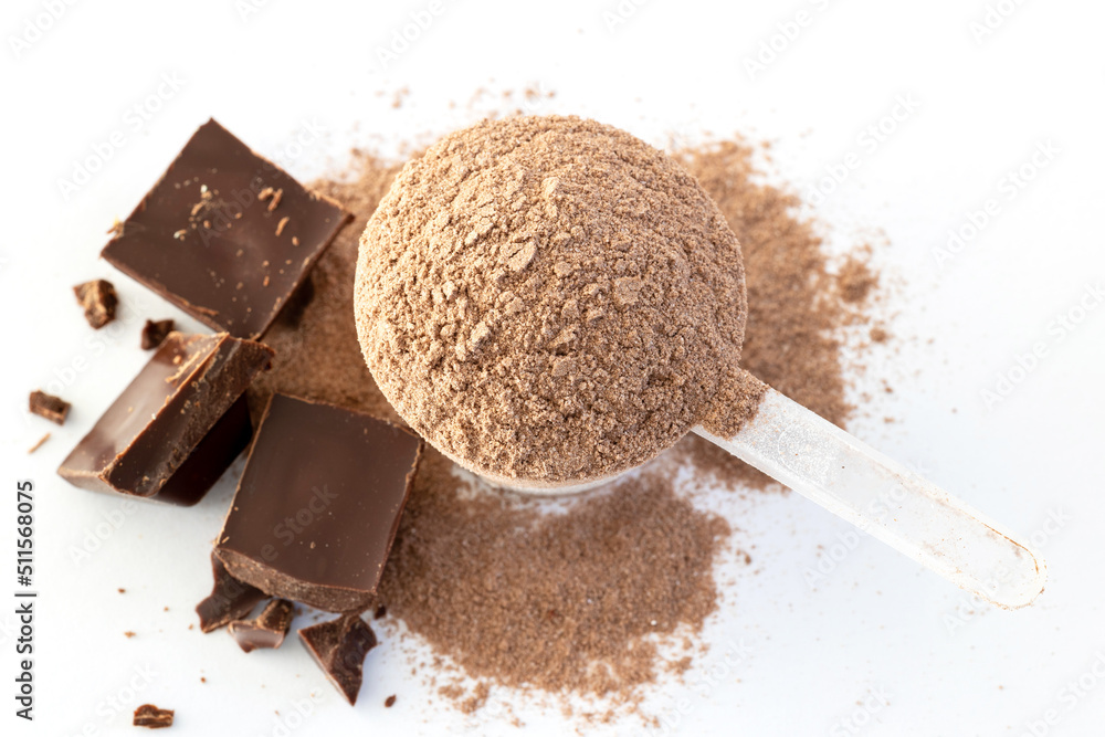 Chocolate Protein powder in Plastic measuring spoon with pieces of ...