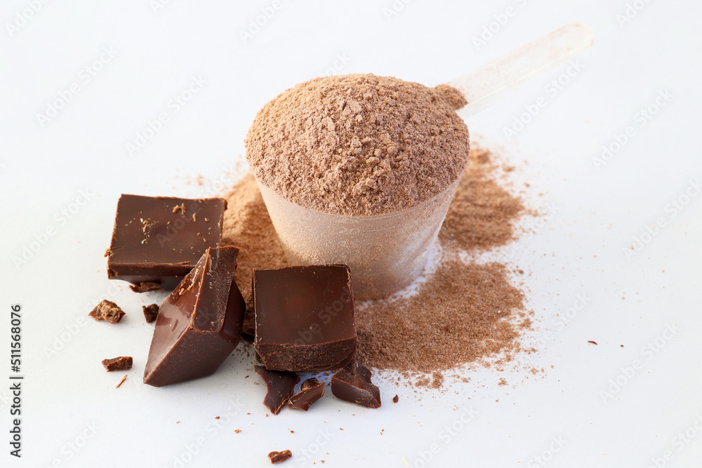 Chocolate Protein powder in Plastic measuring spoon with pieces of ...