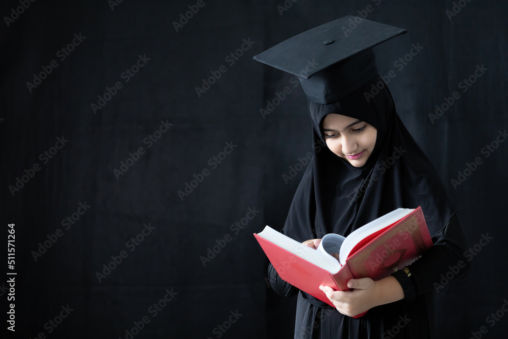 muslim girl with graduation cap and reading a holy book or quran on ...