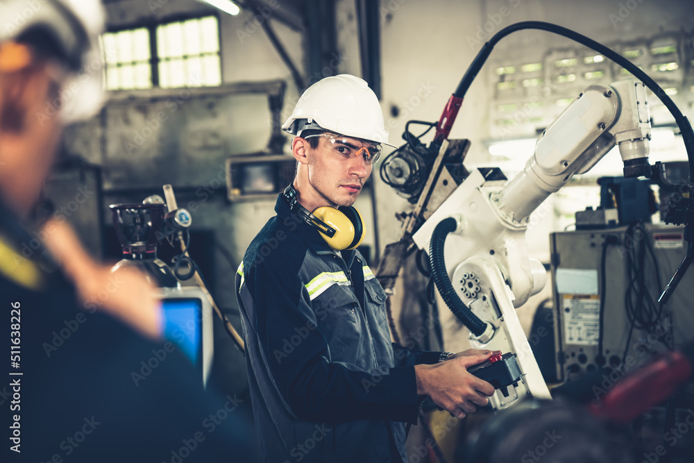 Factory workers working with adept robotic arm in a workshop . Industry ...