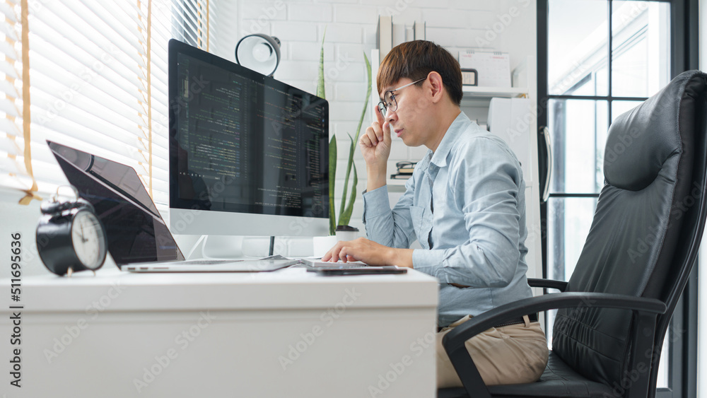 Software development concept, Male programmer looking data on laptop and typing codes on ...