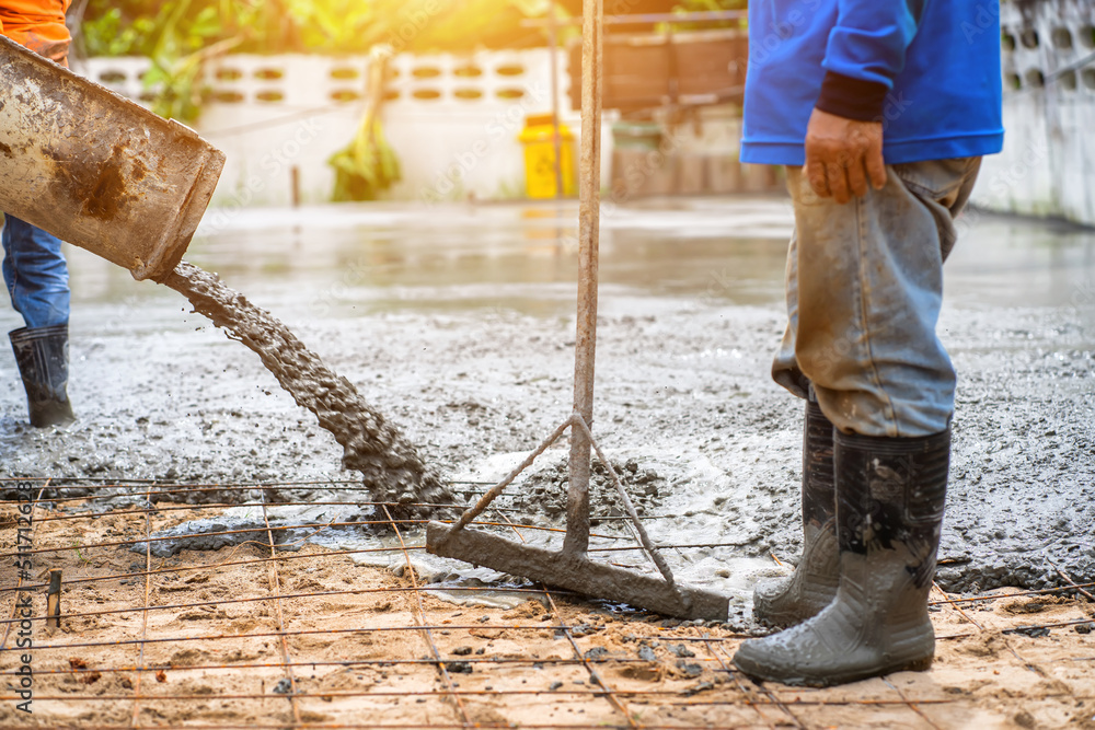 Construction workers are pouring concrete pavement at the construction ...