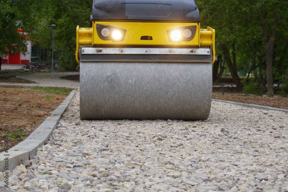 The road roller moves along the road under construction, leveling and ...