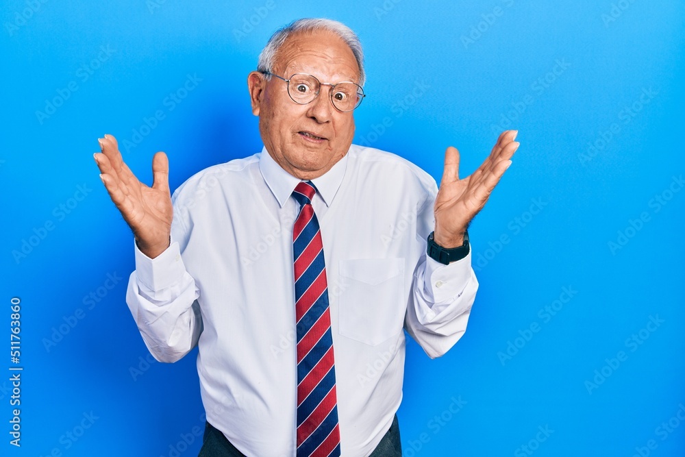 Senior man with grey hair wearing business suit and tie clueless and ...