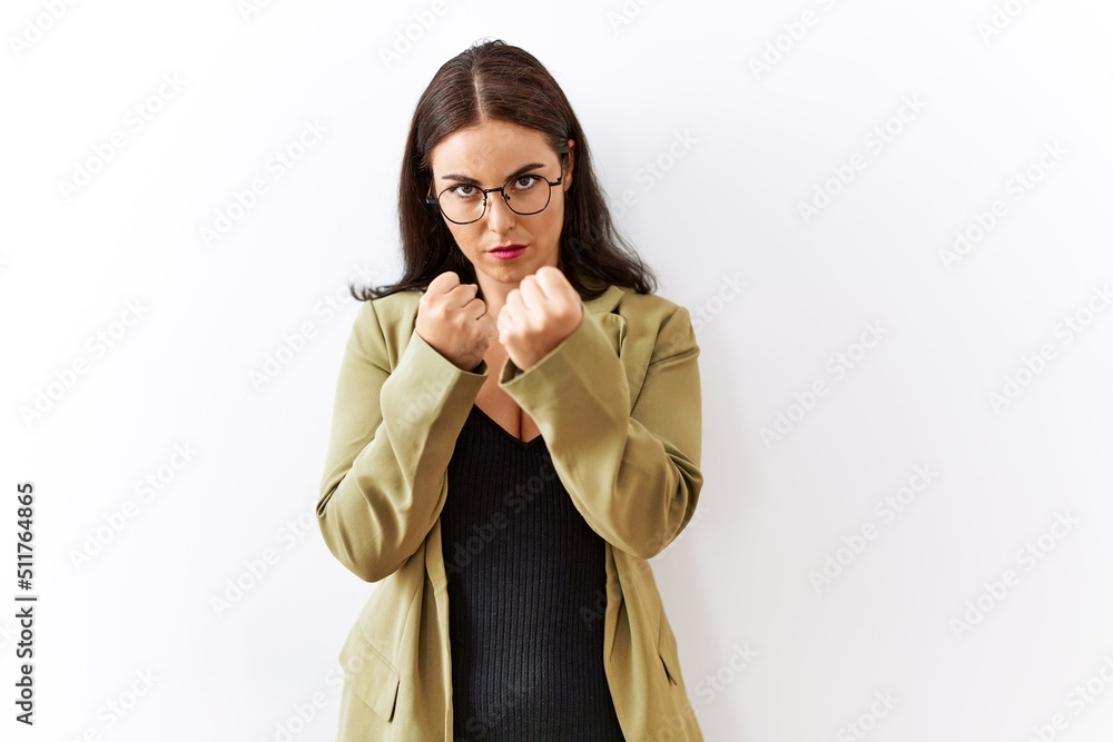 Young brunette woman standing over isolated background ready to fight ...