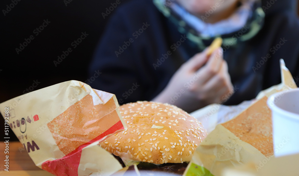 Person eating a Whopper burger with fries from Burger King. Burger King ...