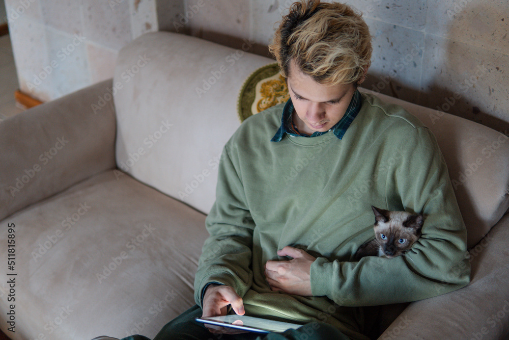 Foto de Siamese cat hiding in the arms of its owner. Man looking at the ...
