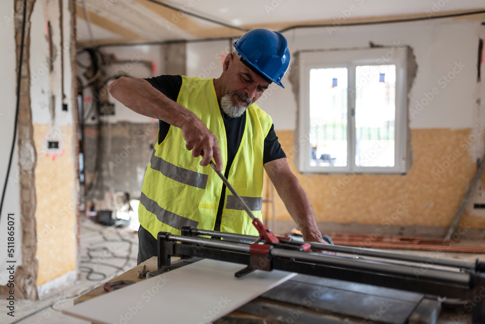 Construction worker prepares the kitchen tiles in a home renovation ...