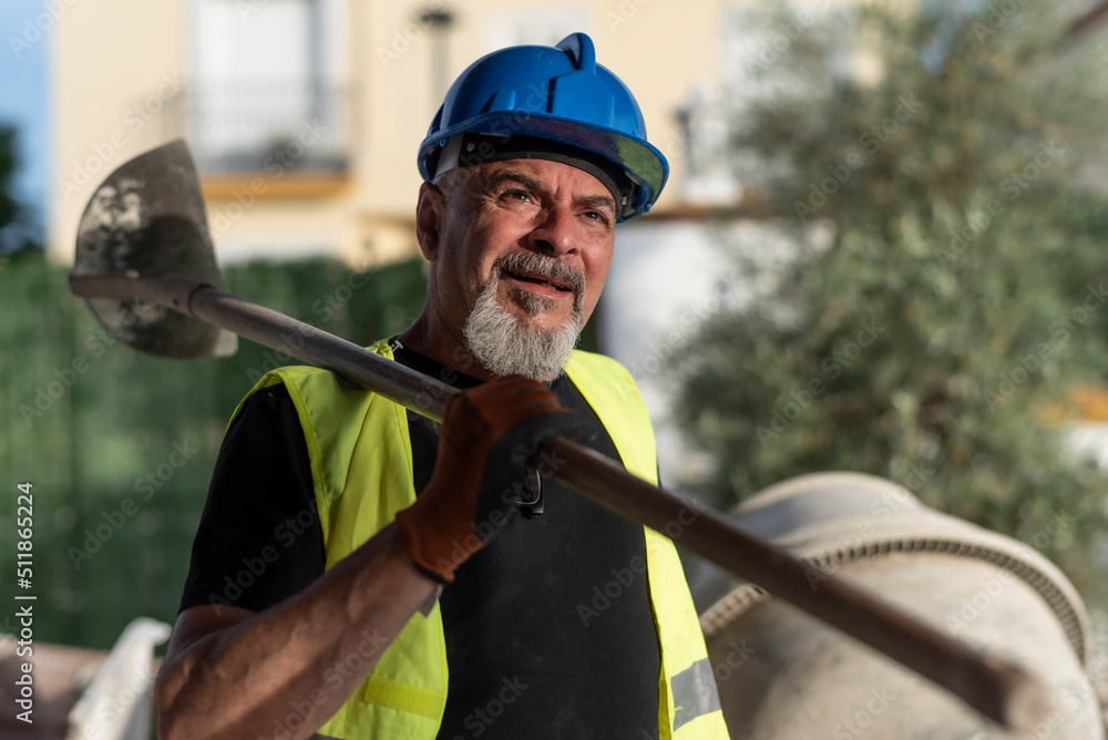 60-year-old outdoor construction worker, working in the concrete mixer ...