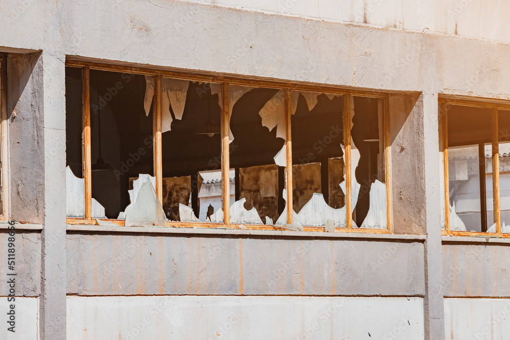 An abandoned factory building with broken windows in the industrial ...