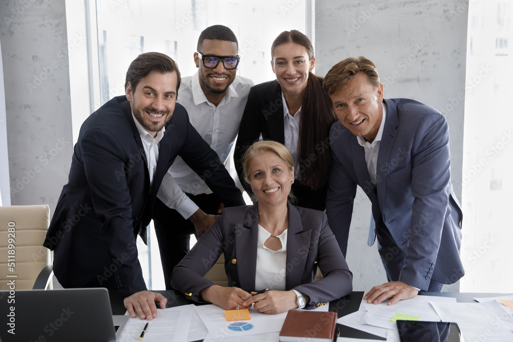 Staff in formal suits pose for corporate picture, gathered together in ...