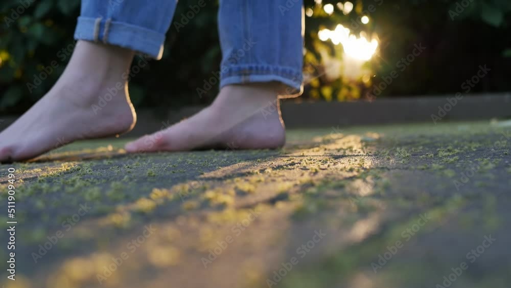 women's bare feet walk along the paving stones of the sidewalk in the ...