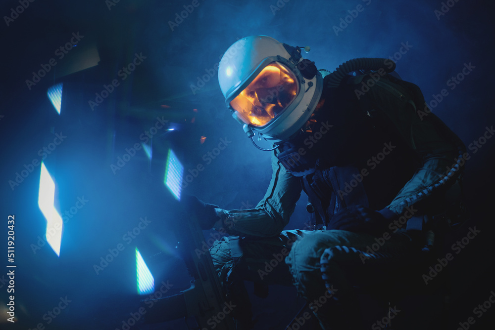 Spaceman or star trooper in the helmet and with rifle in the blue smoke ...