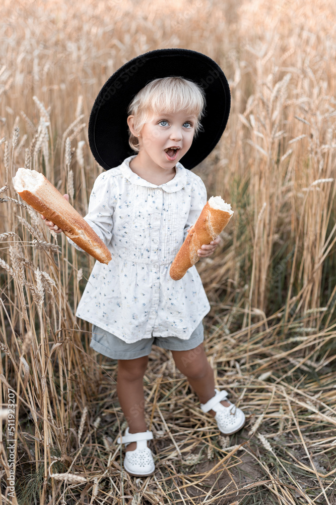 Beautiful portrait of a young child in a field. Children with bread ...