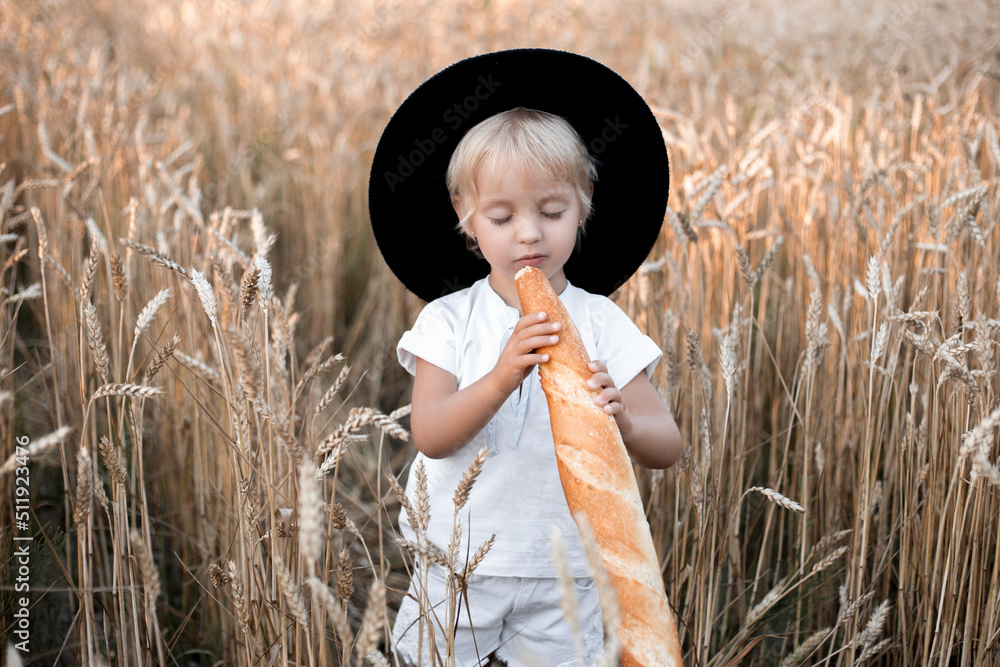 Beautiful portrait of a young child in a field. Children with bread ...