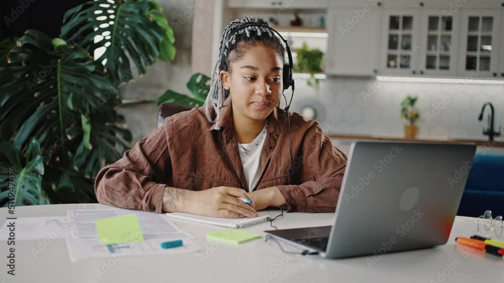 Online education. Young cute black lady student wearing headset with ...