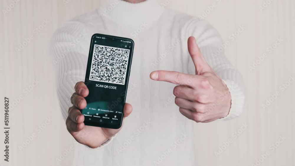 Male hand shows QR code on smartphone on white background. Inscription ...