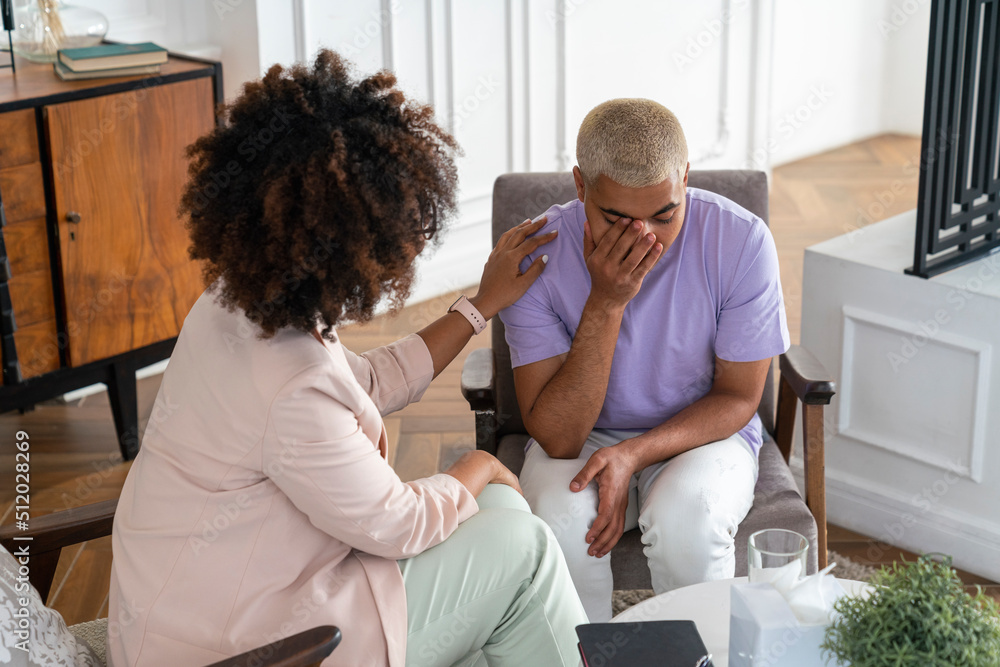 Sad patient with psychologist consoling at workplace Stock Photo ...