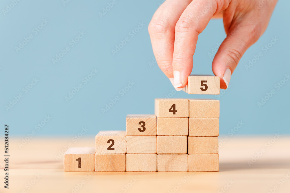 Woman's hand stacking numbered wooden blocks Stock Photo | Adobe Stock Woman's hand stacking numbered wooden blocks Stock Photo | Adobe Stock