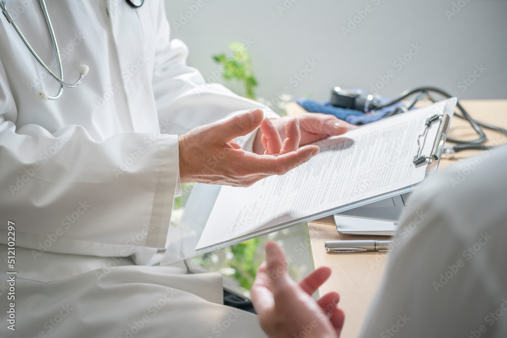 Doctor and patient taking notes or questionnaire in medical surgery ...