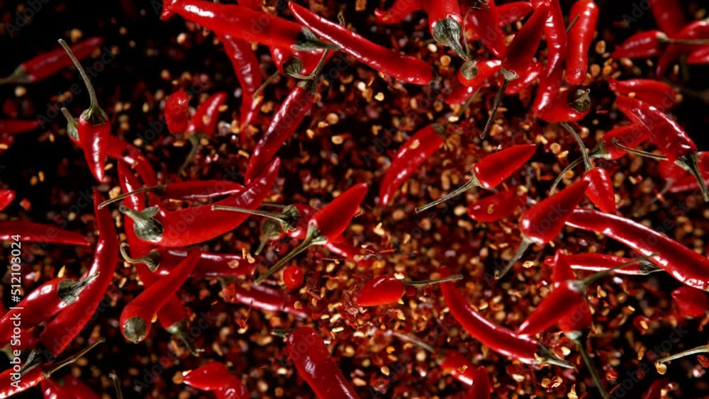 Super slow motion of exploding chilli peppers isolated on black ...