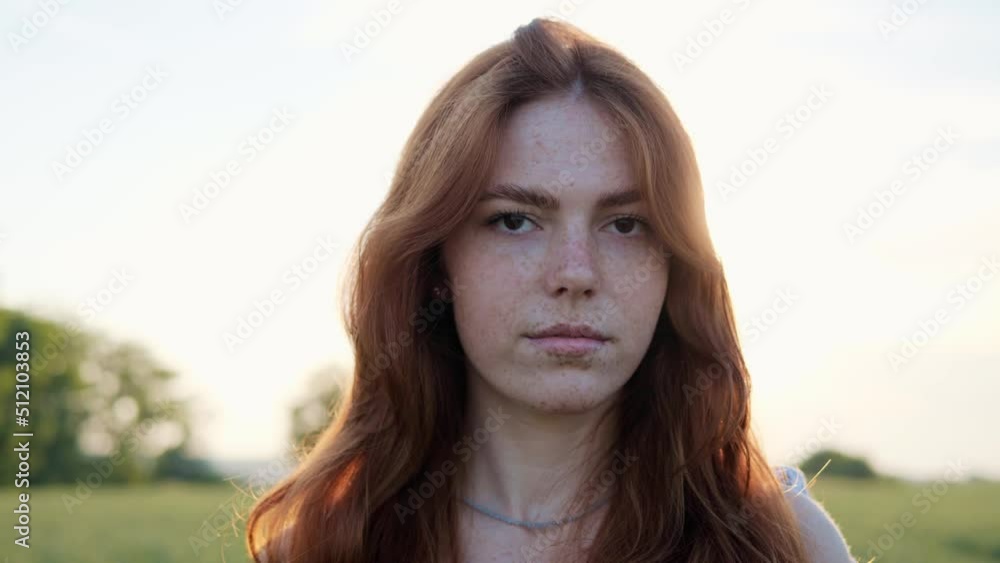 Serious female ginger face with freckles on nature at sunset. Woman ...