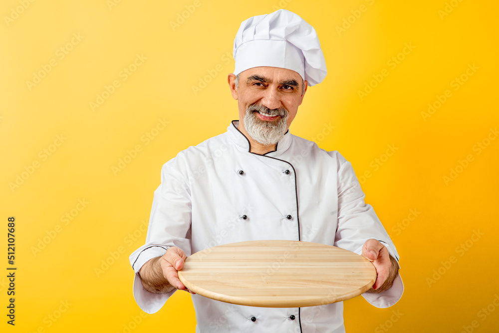 Chef-cooker in a chef's hat and jacket holding an empty wooden tray for ...