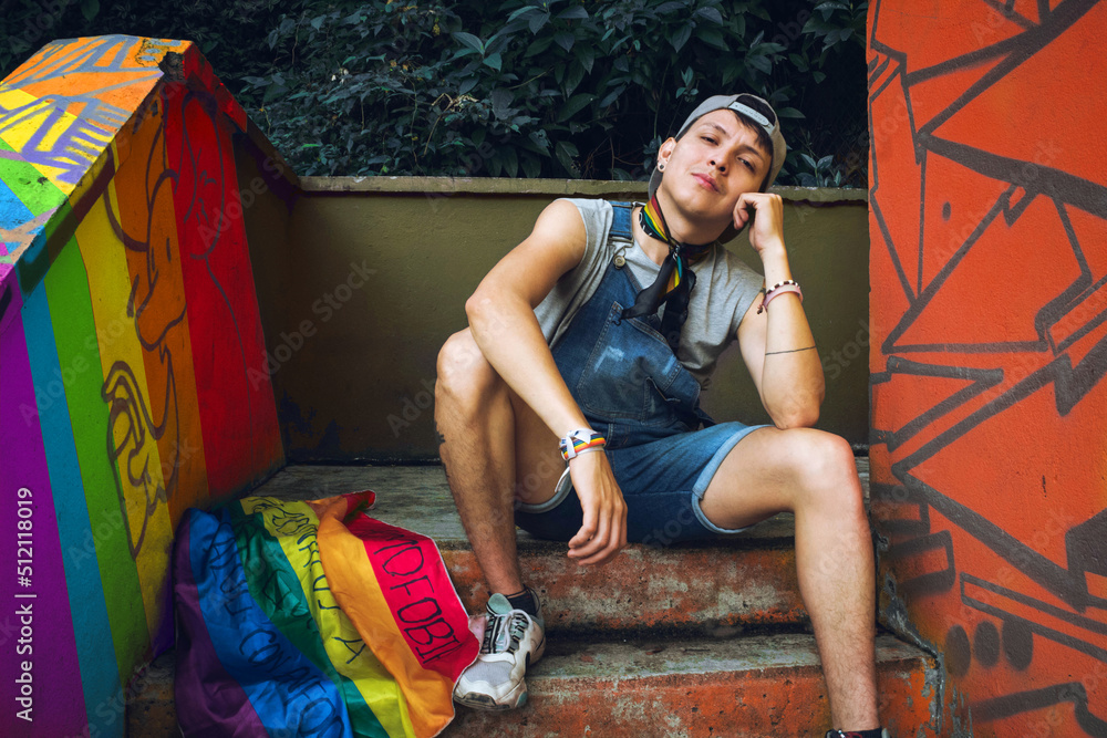 gay boy sitting on stairs with lgbt flag smiling happy Stock Photo ...