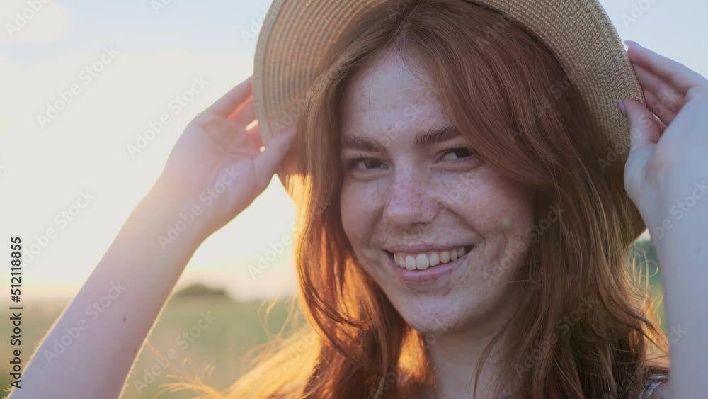 Cheerful red hair girl with freckles dressed in summer dress puts on a ...